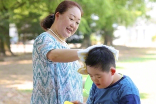 ダウン症の次男・光弘さん㊨の汗を拭く齋藤さん。「この子の笑顔が見たいから、家族みんなが仲良く団結できるんです」と
